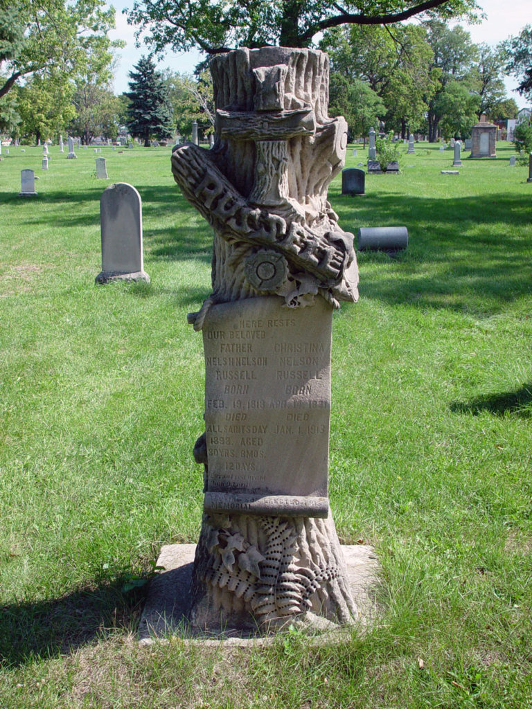 Ornate tree trunk tombstone: Recalls All Saints Day death and symbolism ...